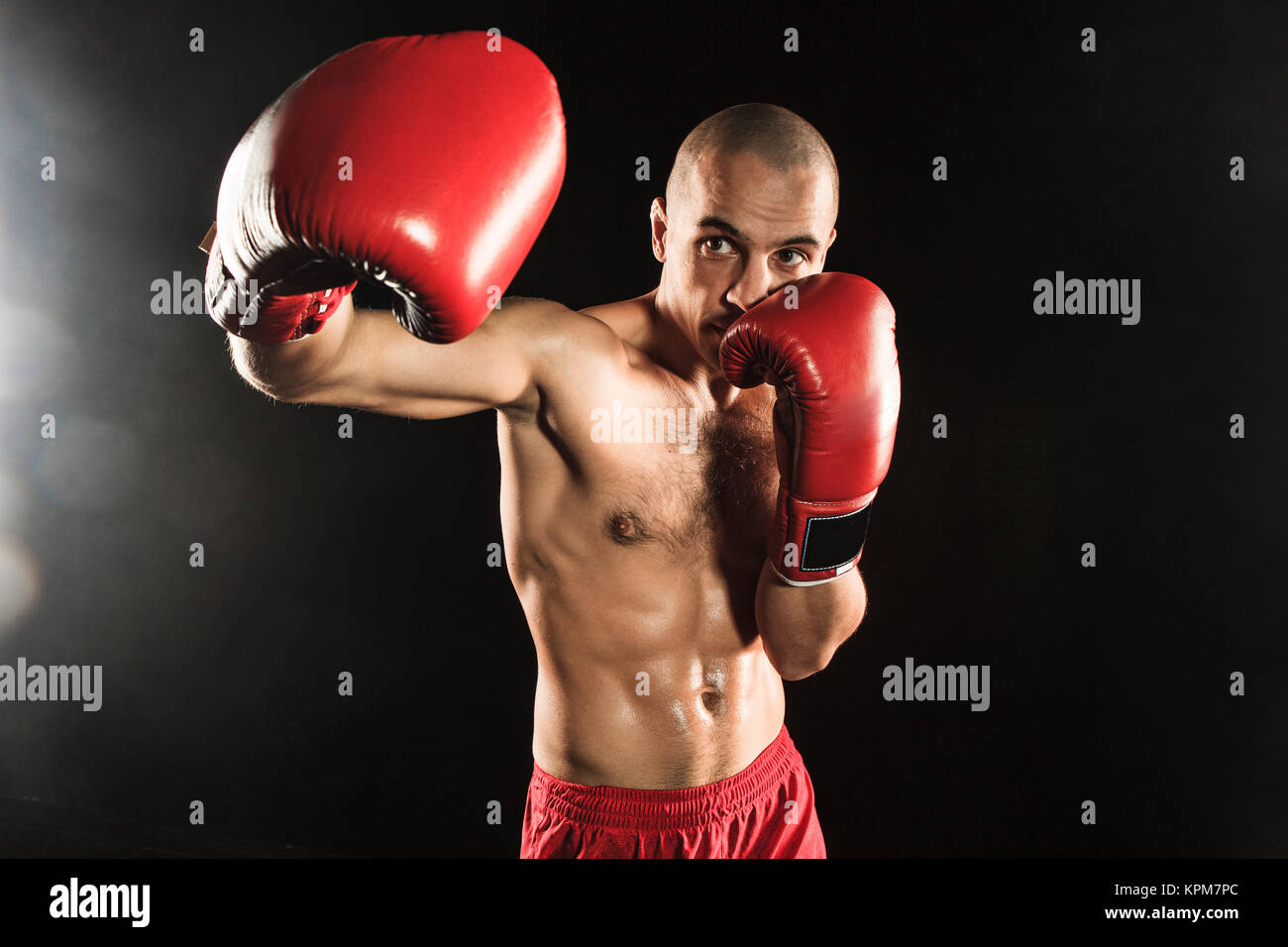 The young man kickboxing on black Stock Photo - Alamy