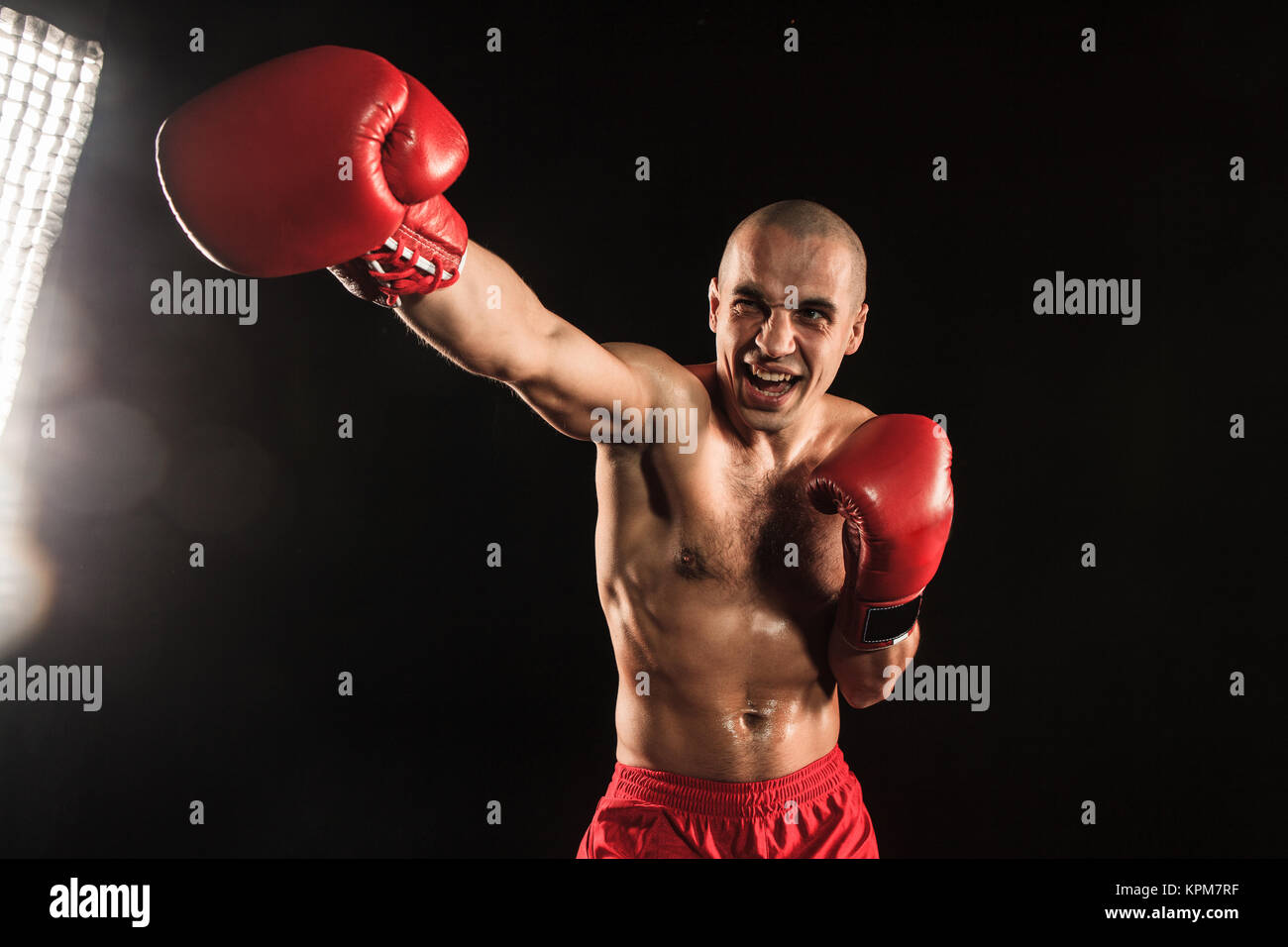 The young man kickboxing on black Stock Photo - Alamy