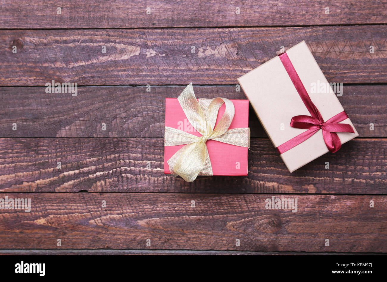 red and gold gift box on wood background Stock Photo - Alamy