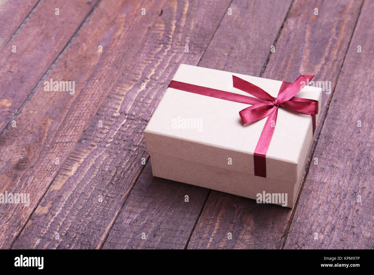red and gold gift box on wood background Stock Photo - Alamy
