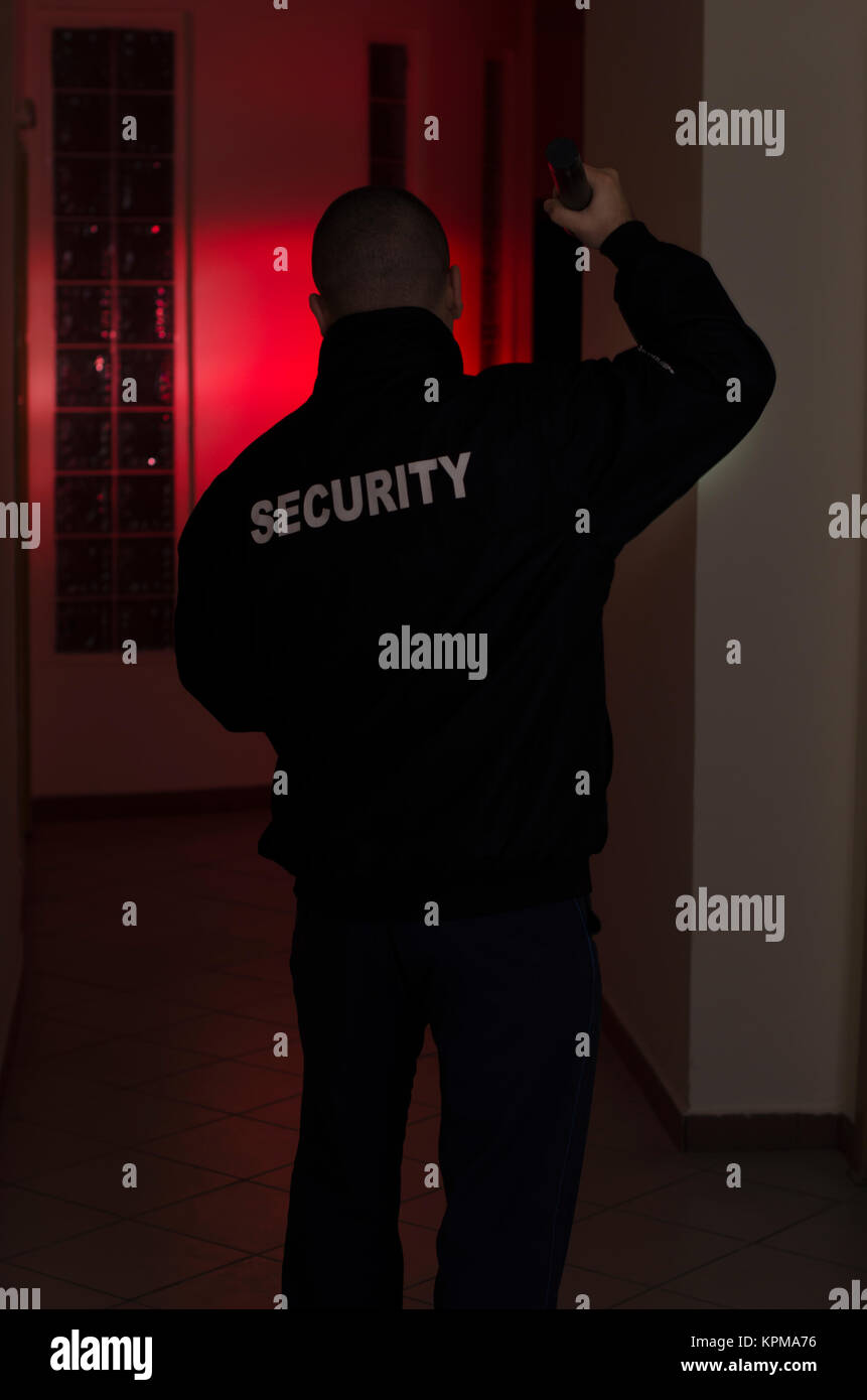 Security man, checks in the dark with flashlight Stock Photo - Alamy