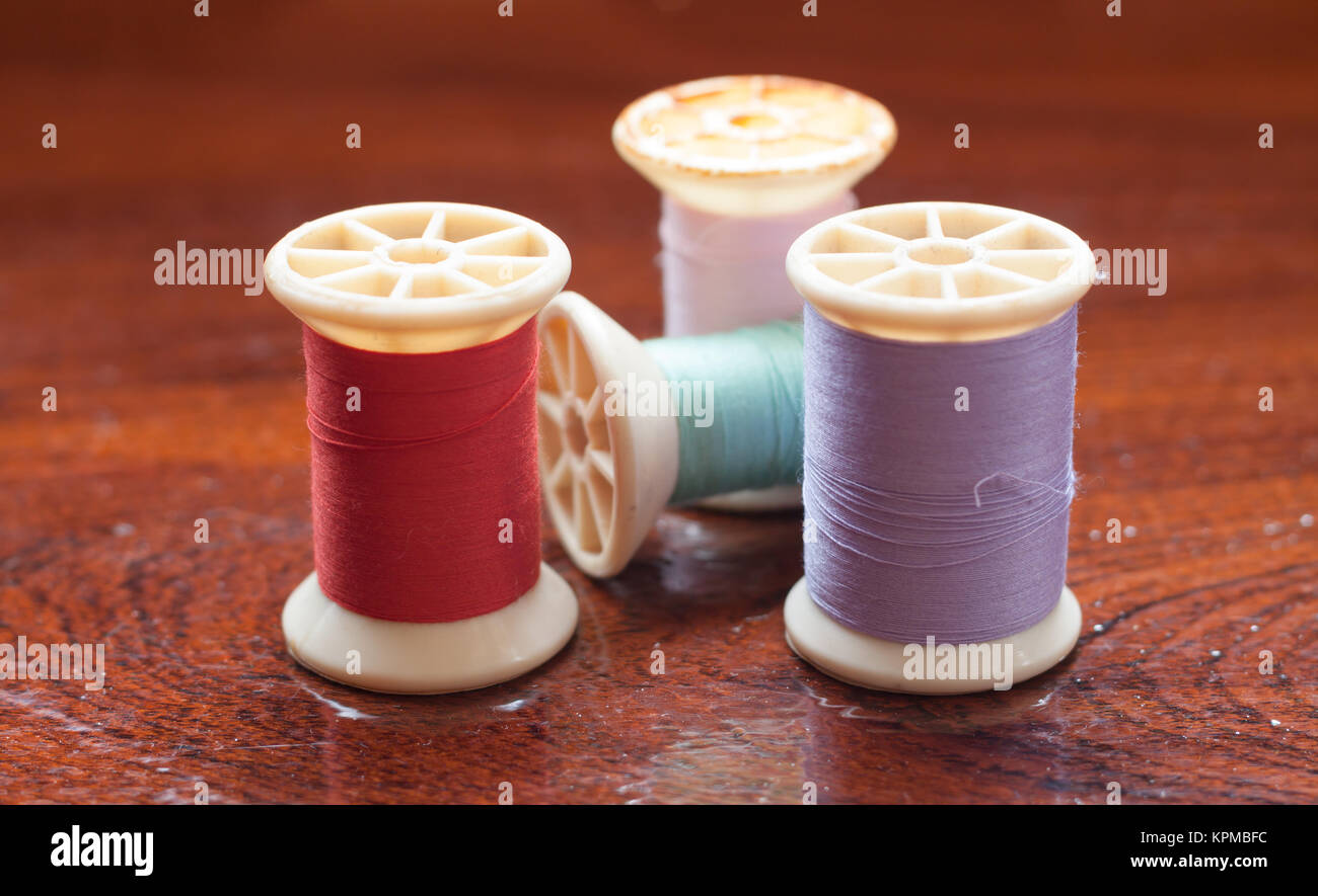 Vintage grunge colorful thread spool on wooden table Stock Photo - Alamy