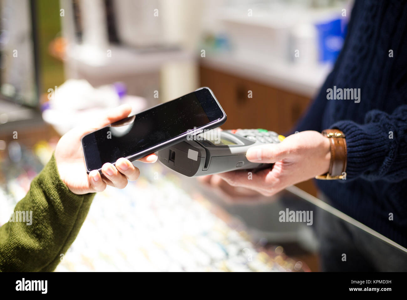Woman pay with mobile phone by NFC Stock Photo - Alamy