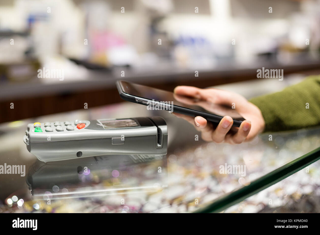Woman pay by mobile phone with NFC Stock Photo - Alamy