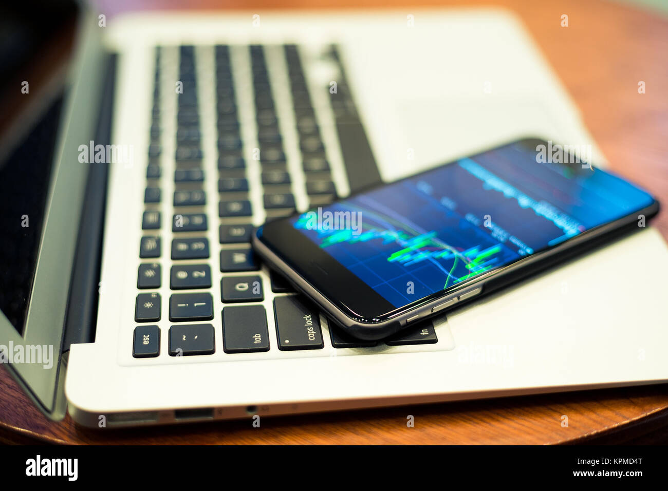 Laptop computer and cellphone with Stock market chart Stock Photo - Alamy
