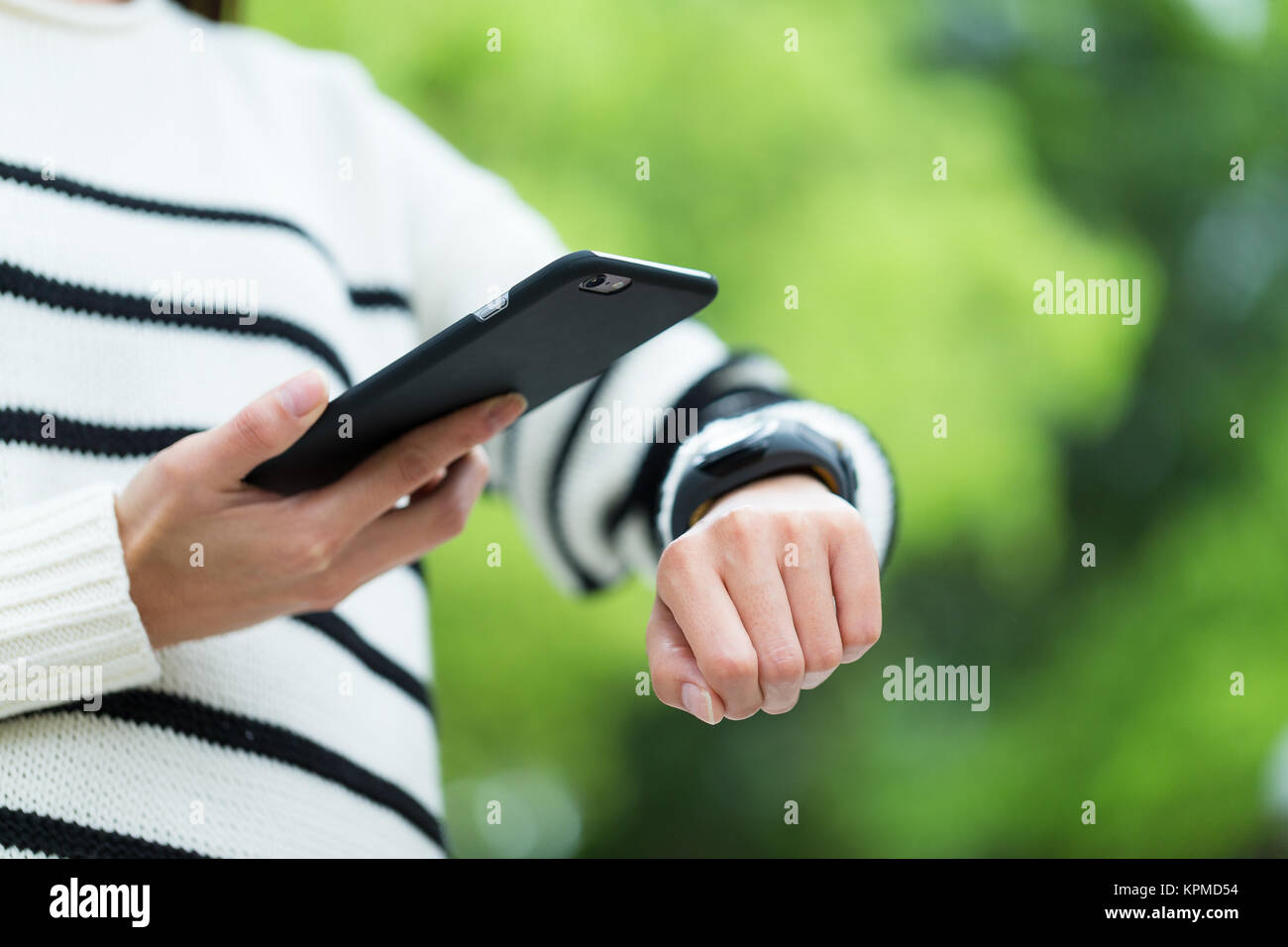 Woman connect the smart watch with cellphone Stock Photo - Alamy