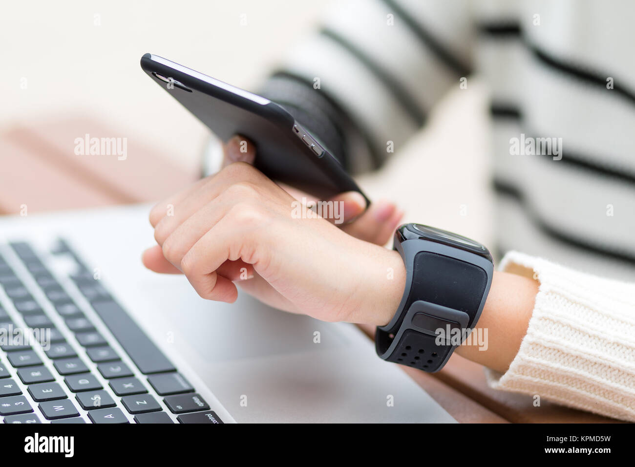 Woman connecting smart watch and cellphone Stock Photo - Alamy
