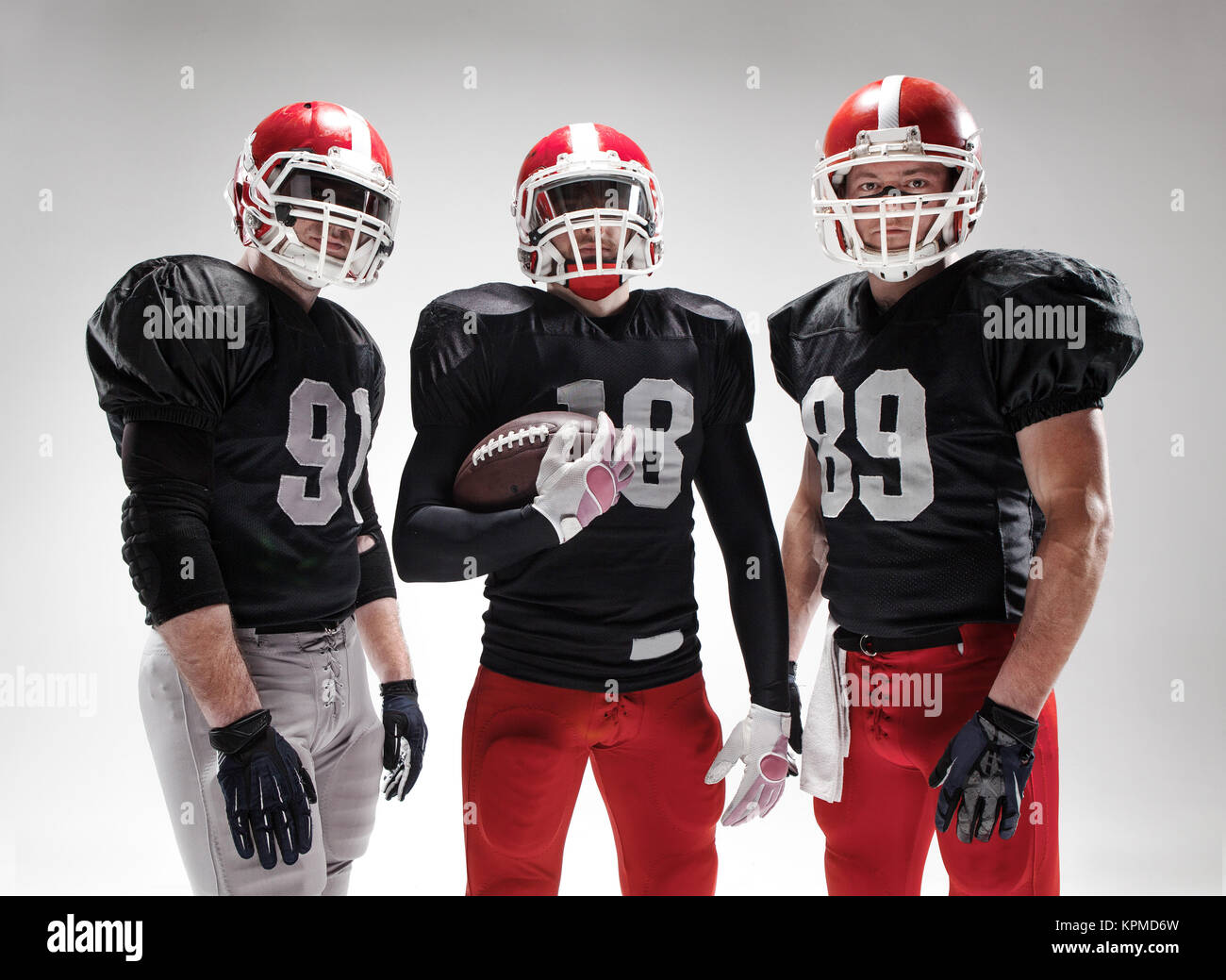 The three american football players posing with ball on white ...
