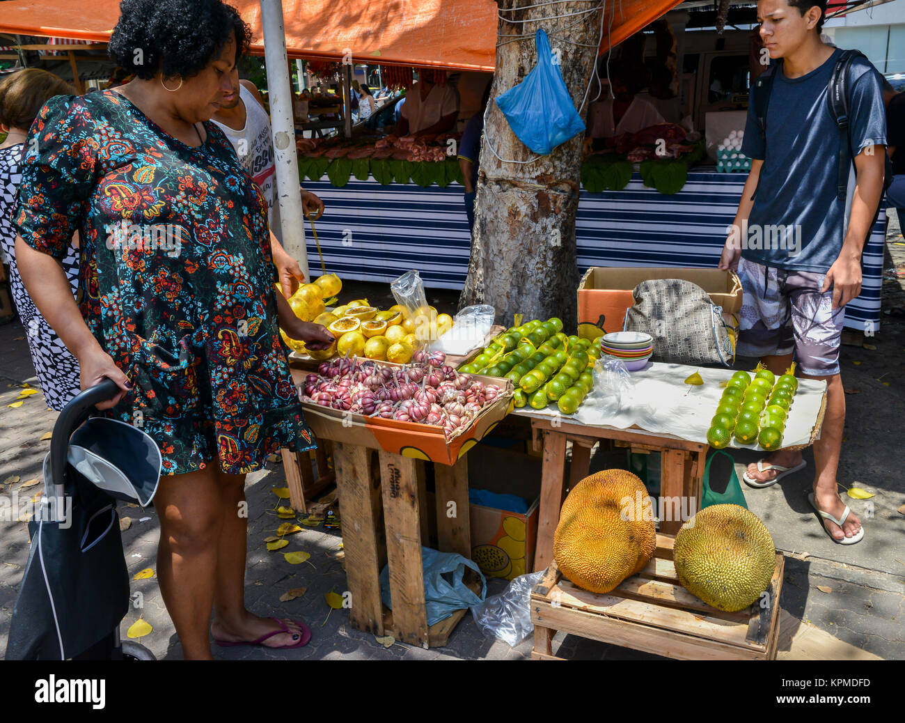Customer inspects tropical fruits in a market in Rio de Janeiro, Brazil ...