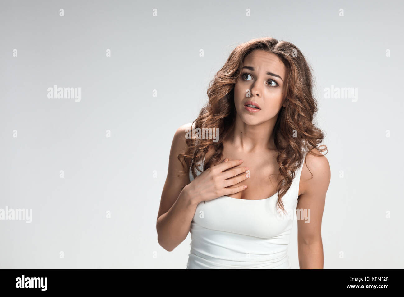 Woman is looking imploring over gray background Stock Photo - Alamy