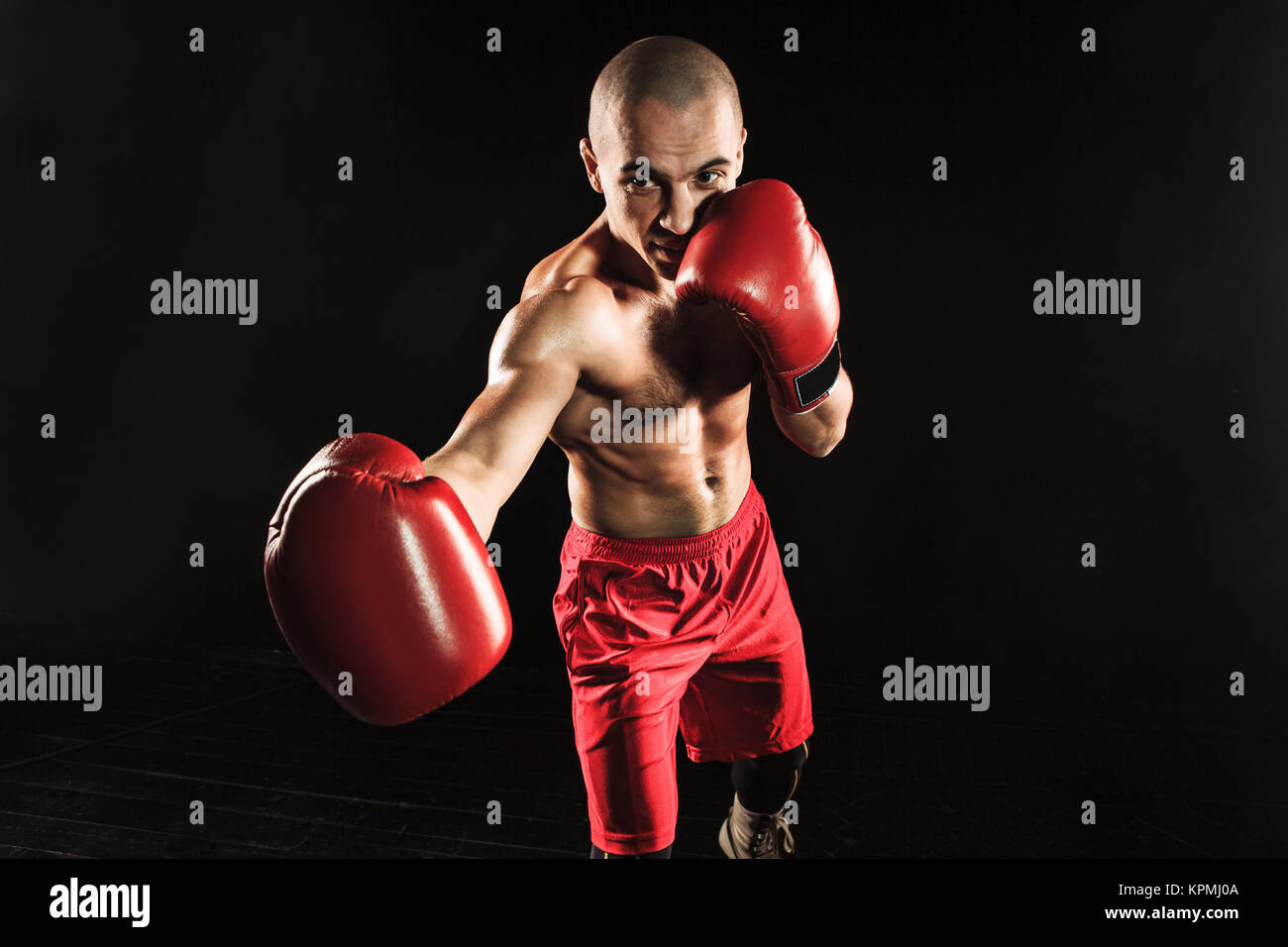 The young man kickboxing on black Stock Photo - Alamy