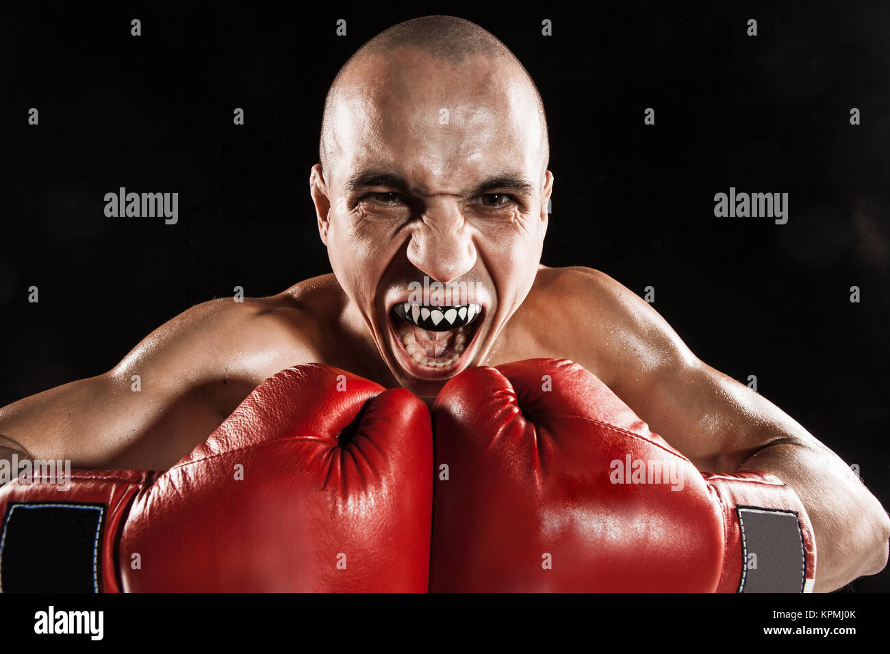 The young man kickboxing on black with kapa in mouth Stock Photo - Alamy
