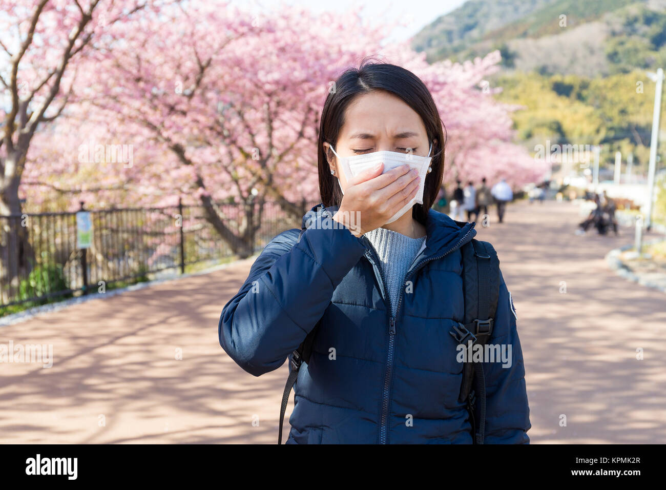 Woman feeling unwell with Pollen allergy under sakura tree Stock Photo ...