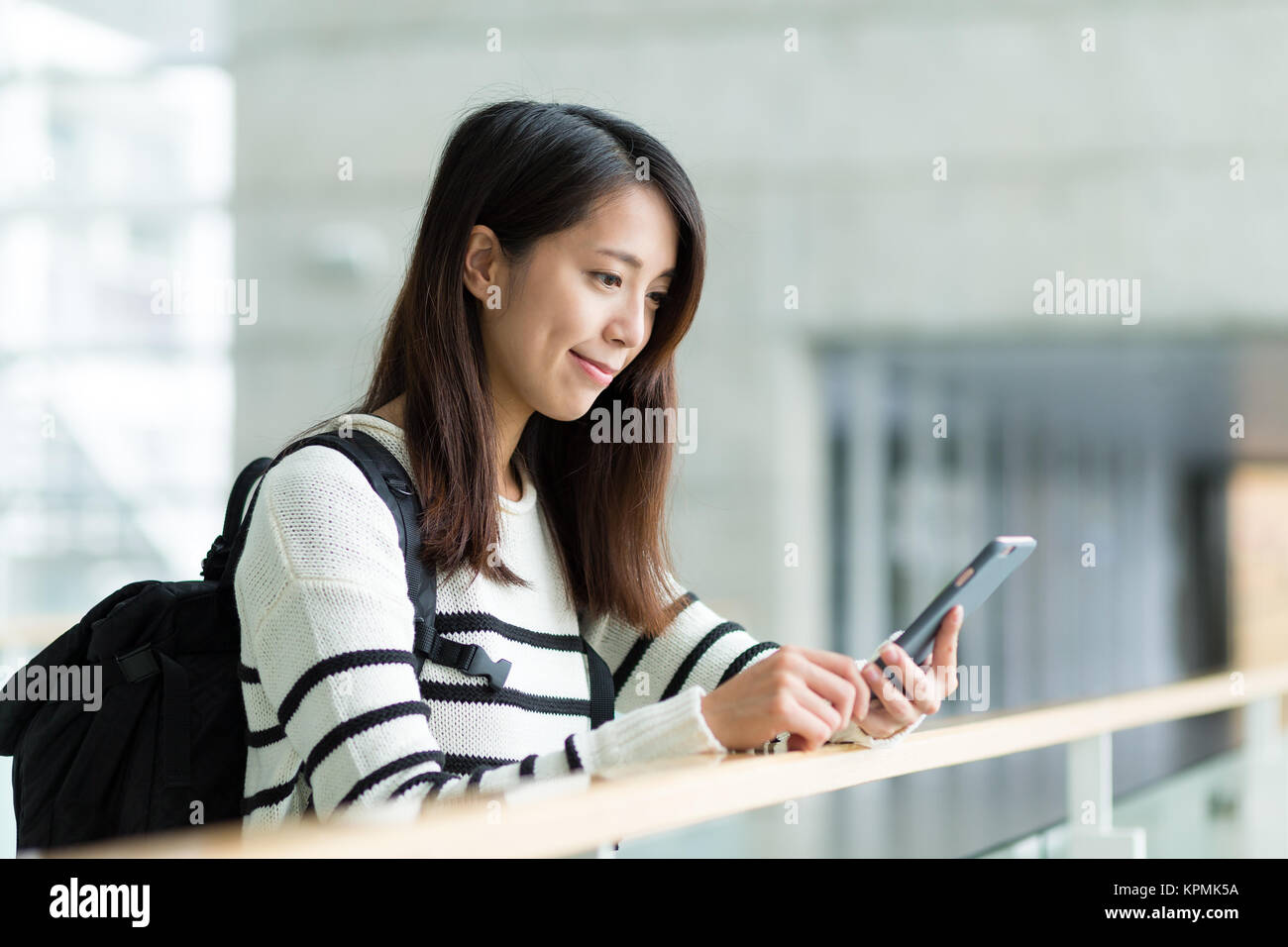 Student with backpack and read the message on cellphone Stock Photo - Alamy