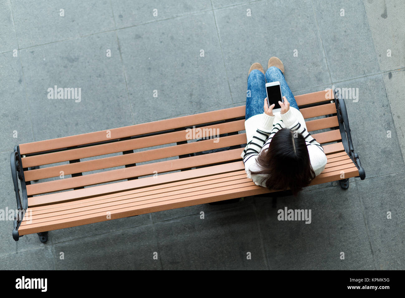 Woman sitting on bench and use of mobile phone Stock Photo - Alamy