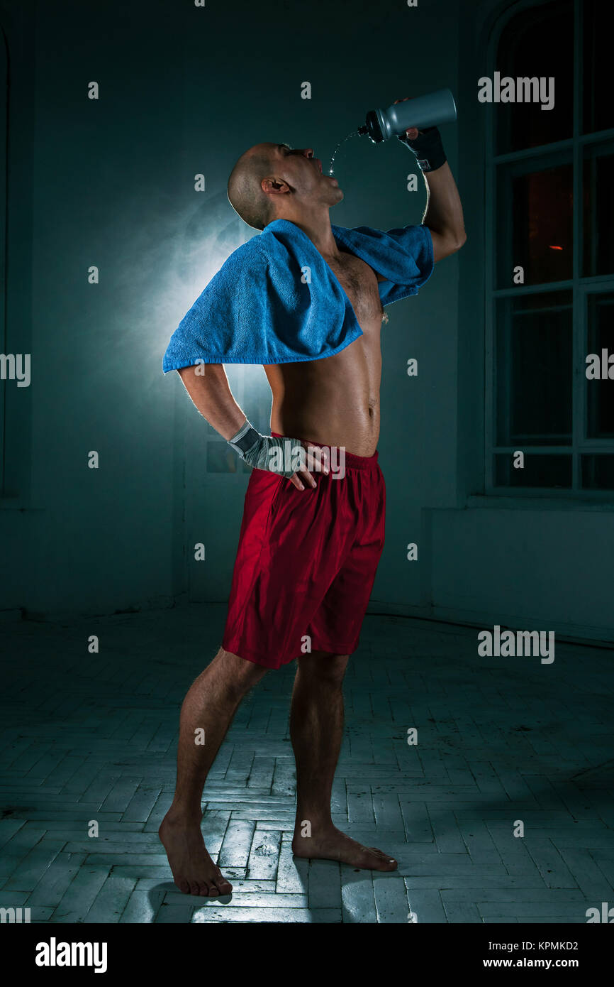 The young man kickboxing on black background Stock Photo - Alamy