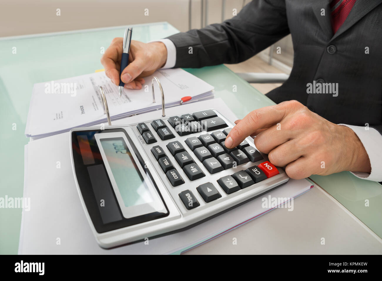 Close-up Of Businessman Calculating Invoice Using Calculator Stock ...