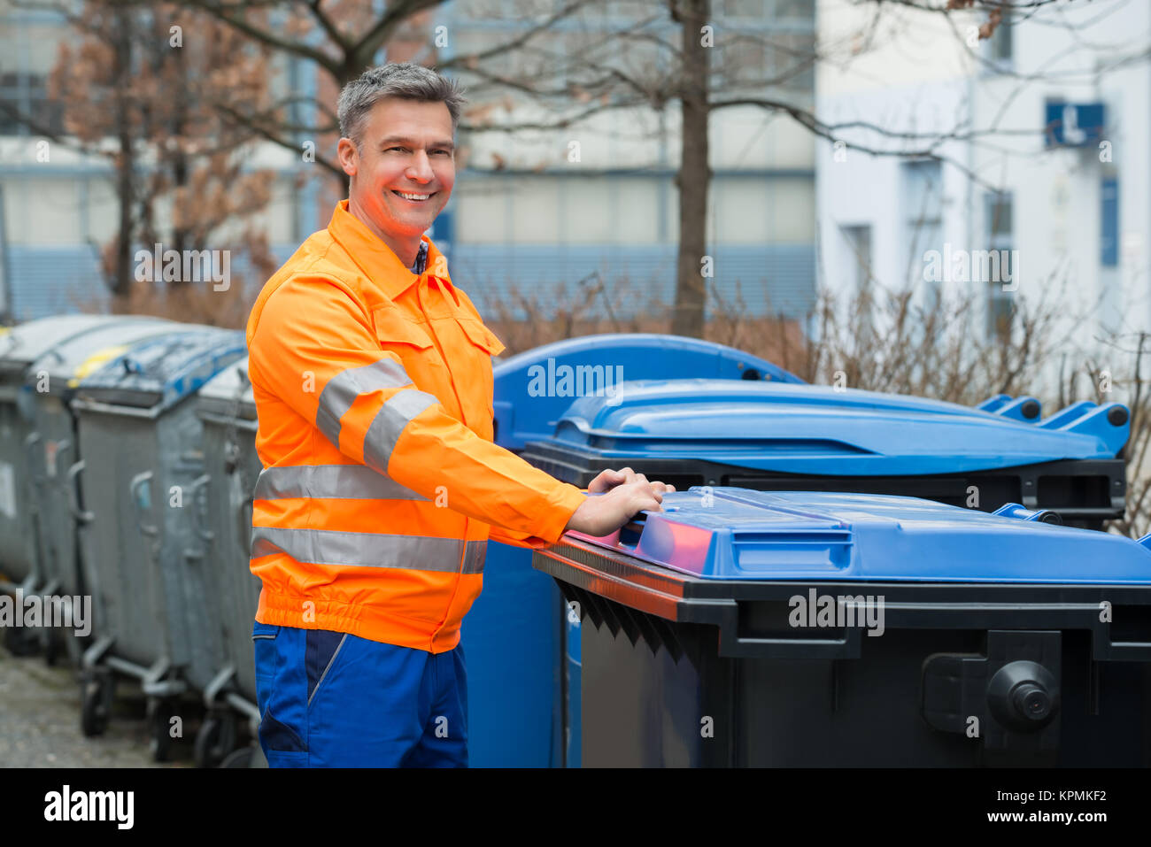 Working Man Standing Near Dustbin On Street Stock Photo - Alamy