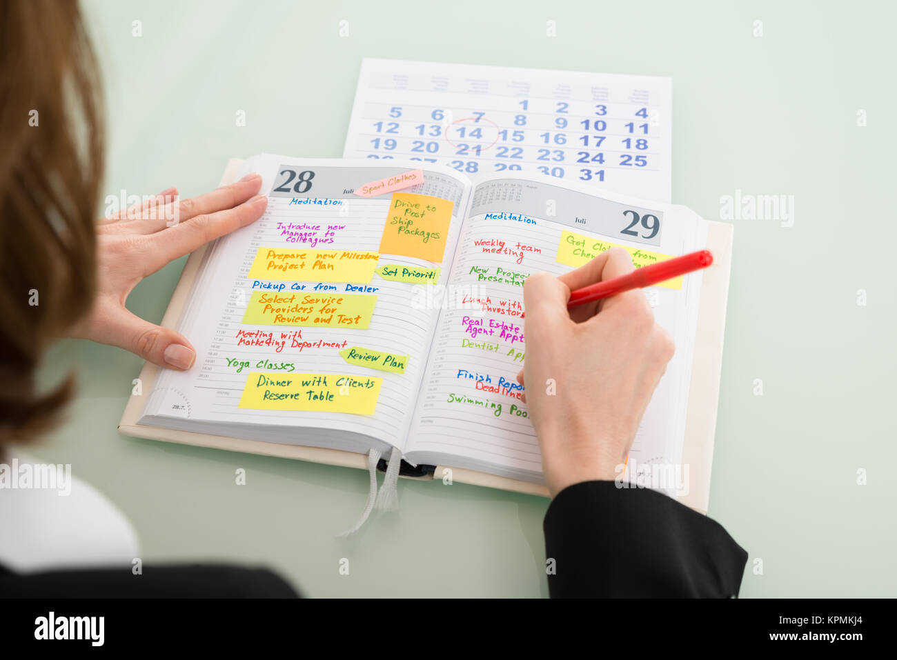 Businesswoman With Calendar Writing Schedule In Diary Stock Photo - Alamy
