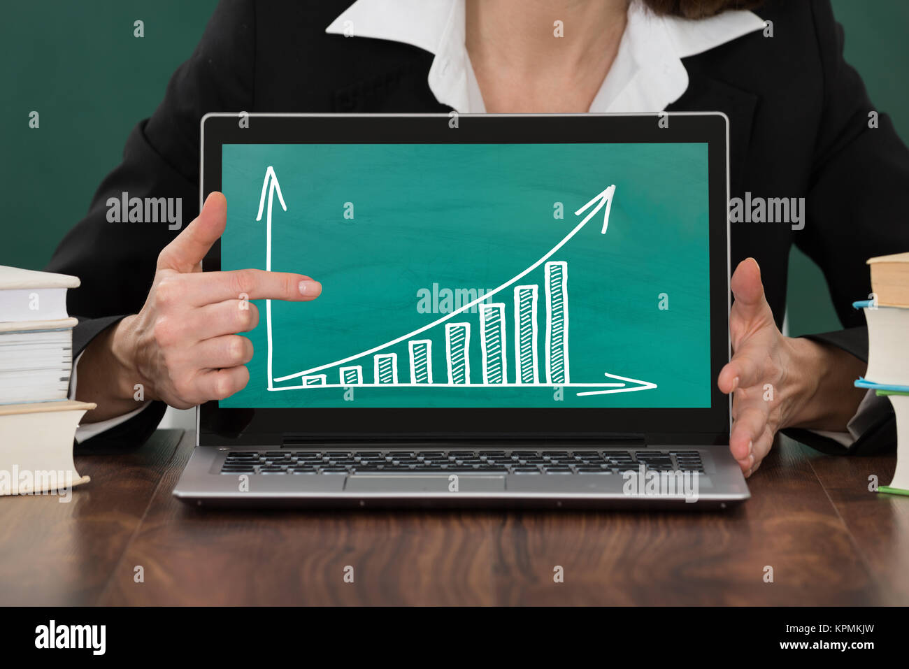 Female Teacher Pointing At Graph On Laptop Stock Photo - Alamy
