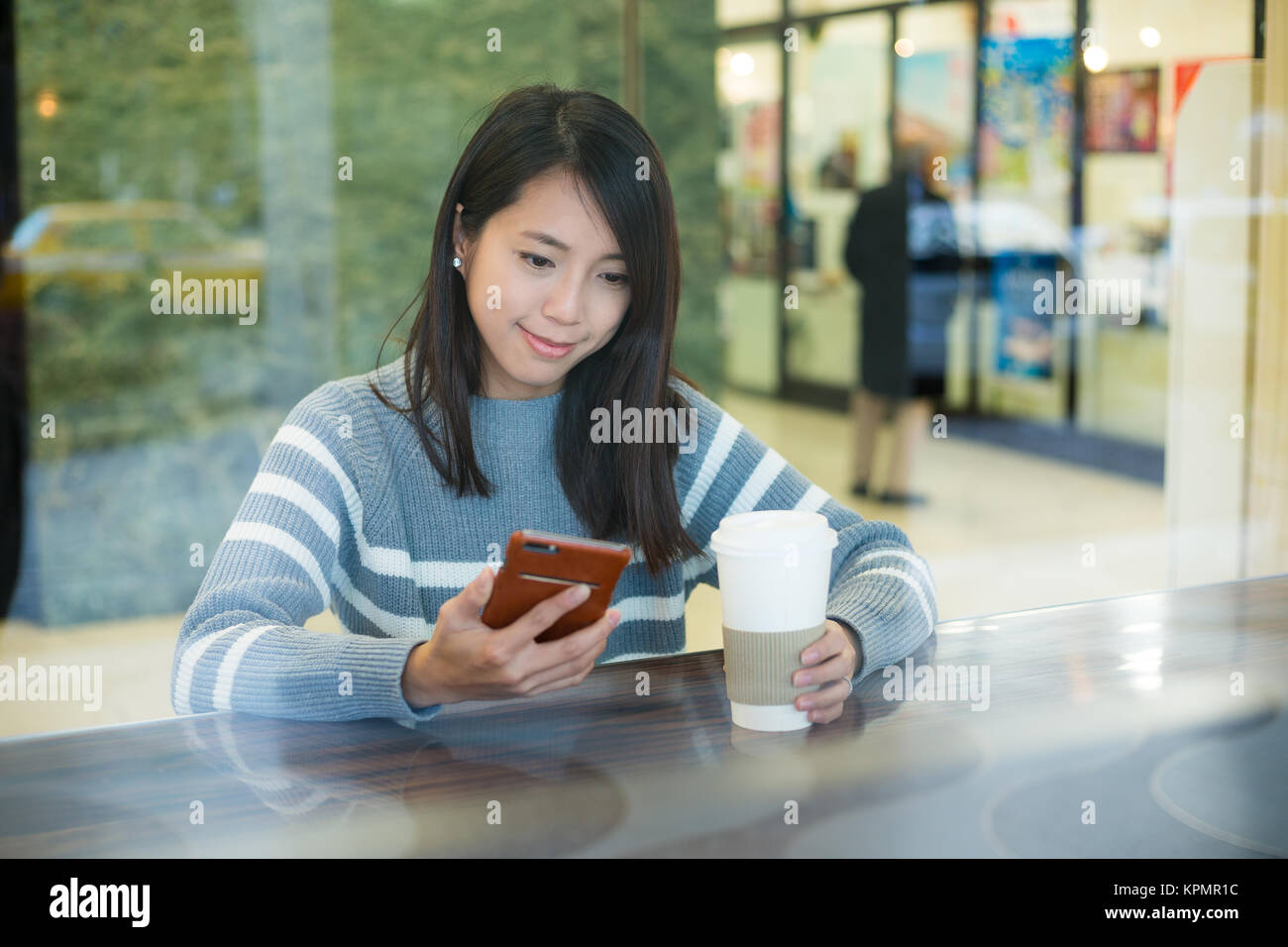 Woman use of cellphone in coffee shop Stock Photo - Alamy