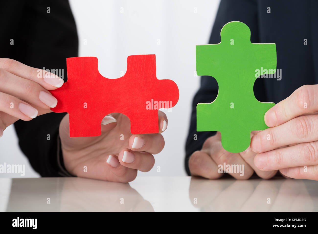 Two businessmen holding puzzle pieces hi-res stock photography and ...