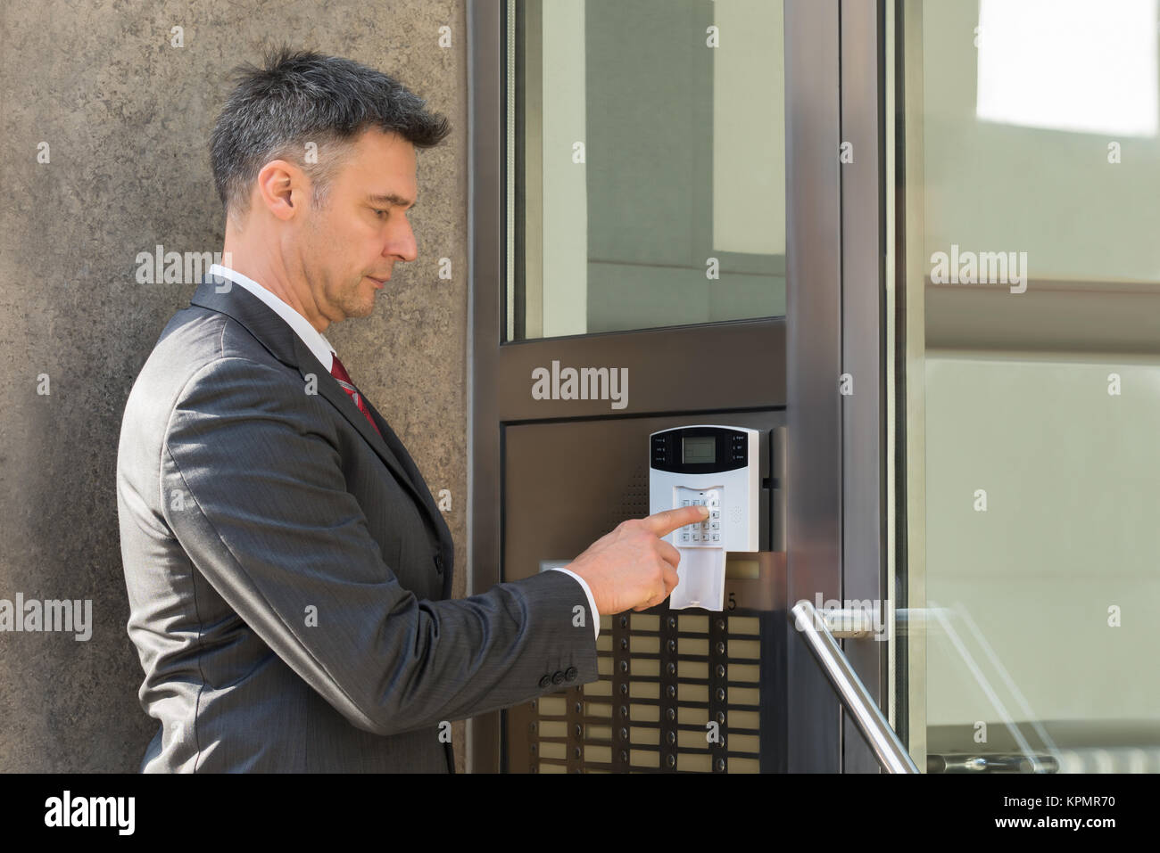 Businessman Using Door Security System On Wall Stock Photo - Alamy