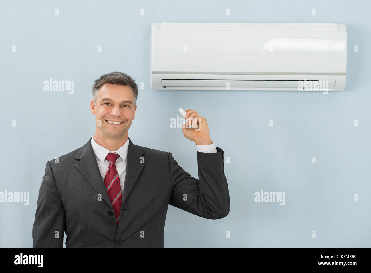 Businessman Holding Remote Control Air Conditioner In Office Stock ...