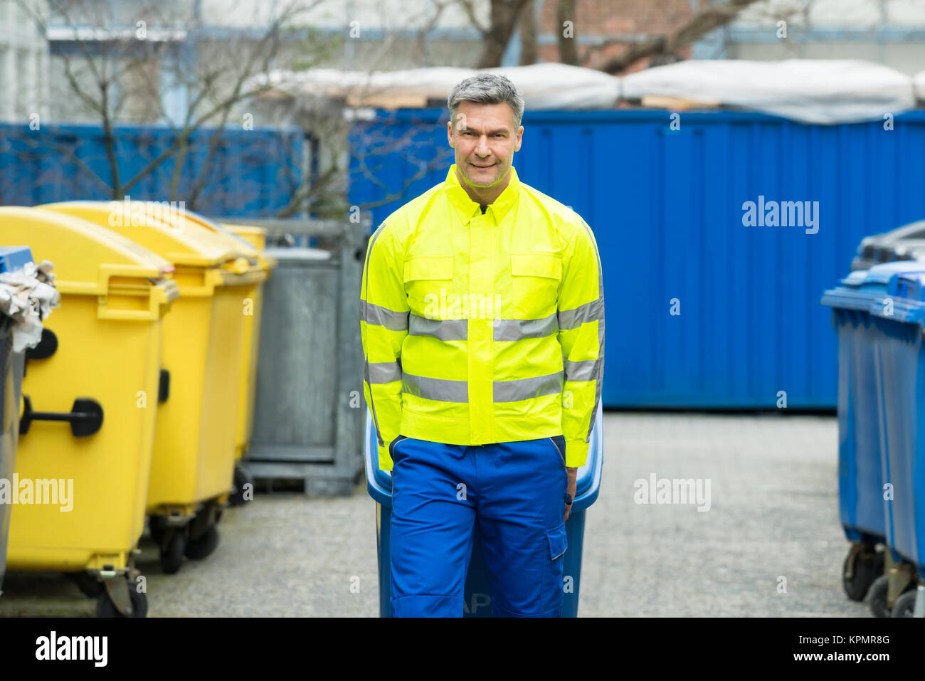 Male Worker Walking With Dustbin On Street Stock Photo - Alamy