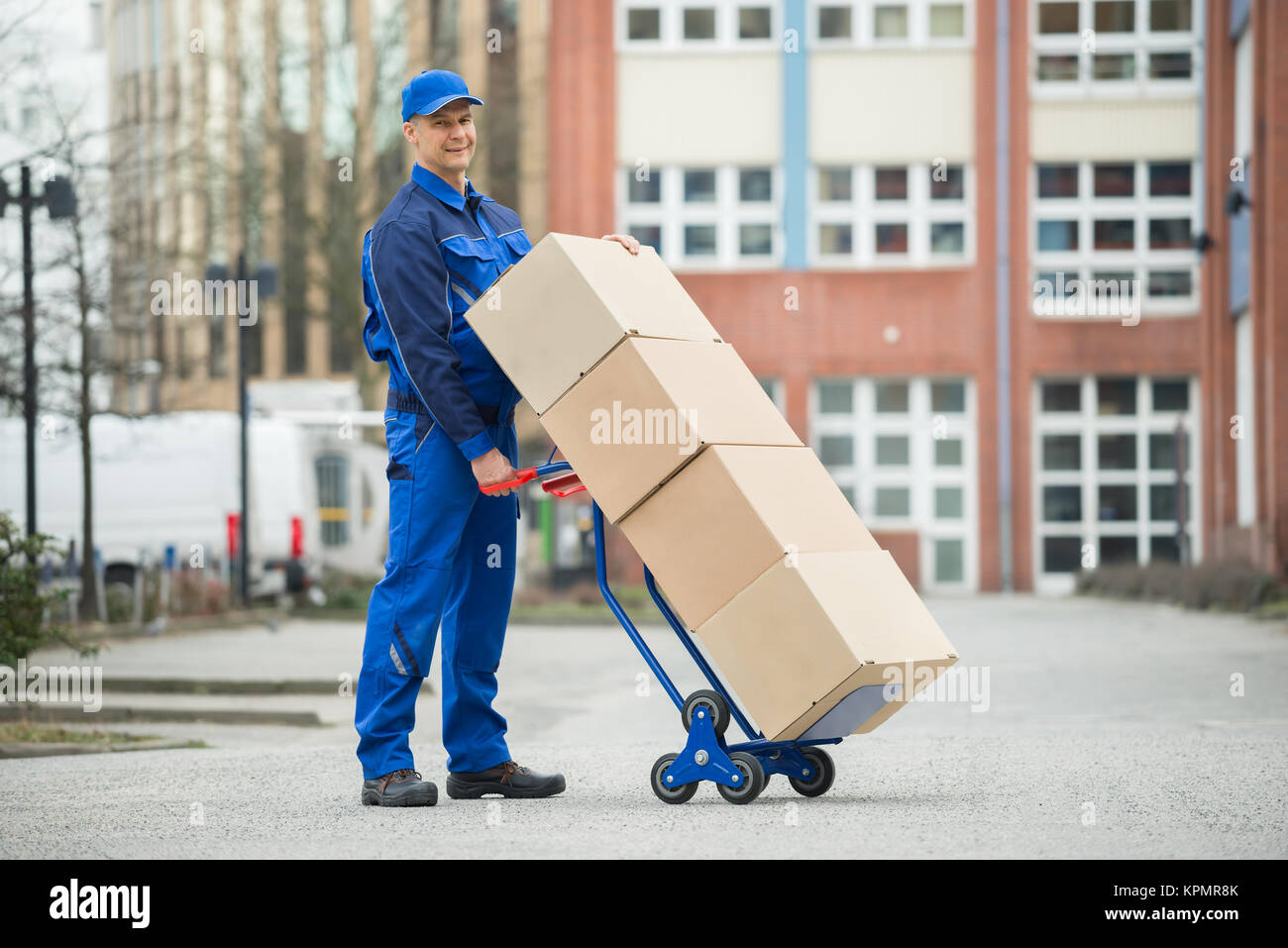 Deliveryman Holding Trolley Loaded With Cardboard Boxes Stock Photo - Alamy