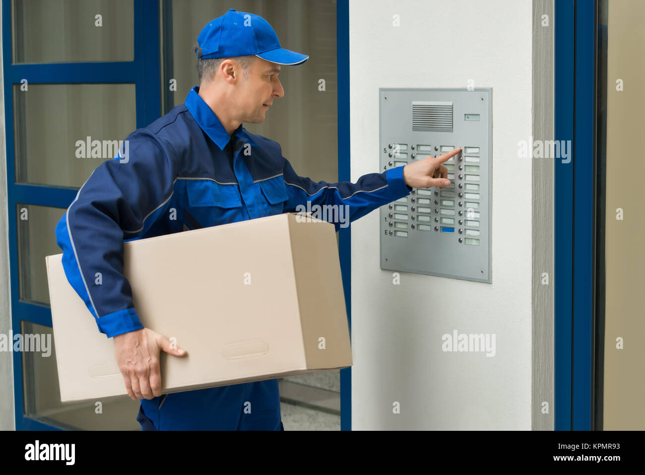 Delivery Man Pressing Button Of Intercom To Enter Building Stock Photo ...