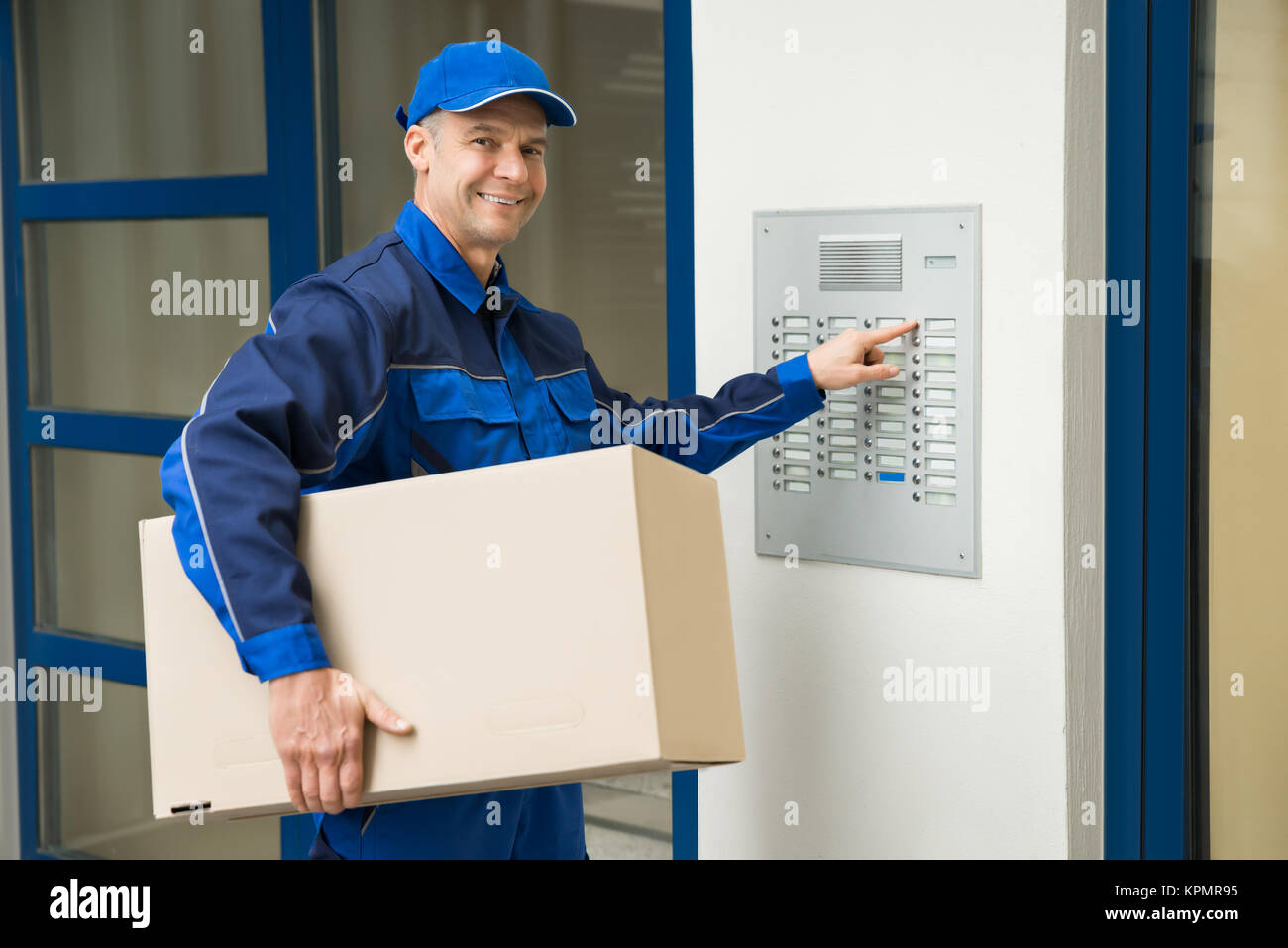 Delivery Man Pressing Button Of Intercom To Enter Building Stock Photo ...