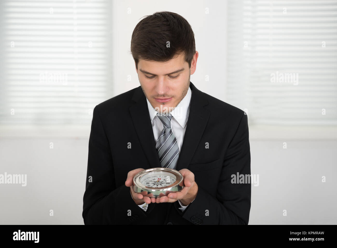 Businessman Holding Compass Stock Photo - Alamy