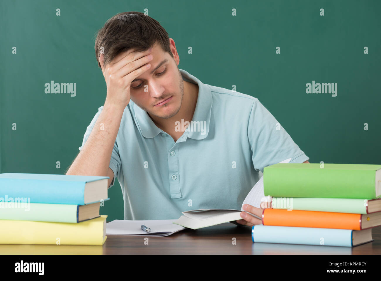 Man With Books At Desk Stock Photo - Alamy