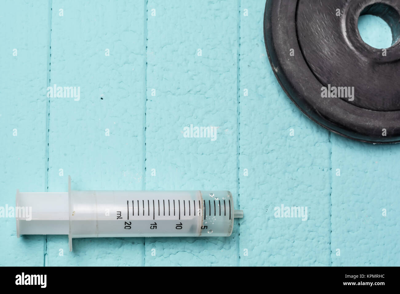 Injection and disc from dumbbell. Close-up. Blue background Stock Photo ...