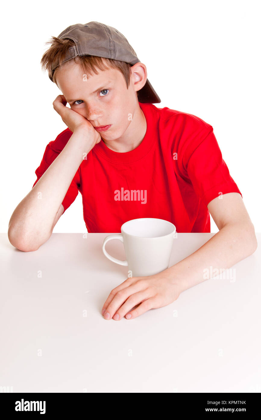 Pouting child behind white cup Stock Photo - Alamy