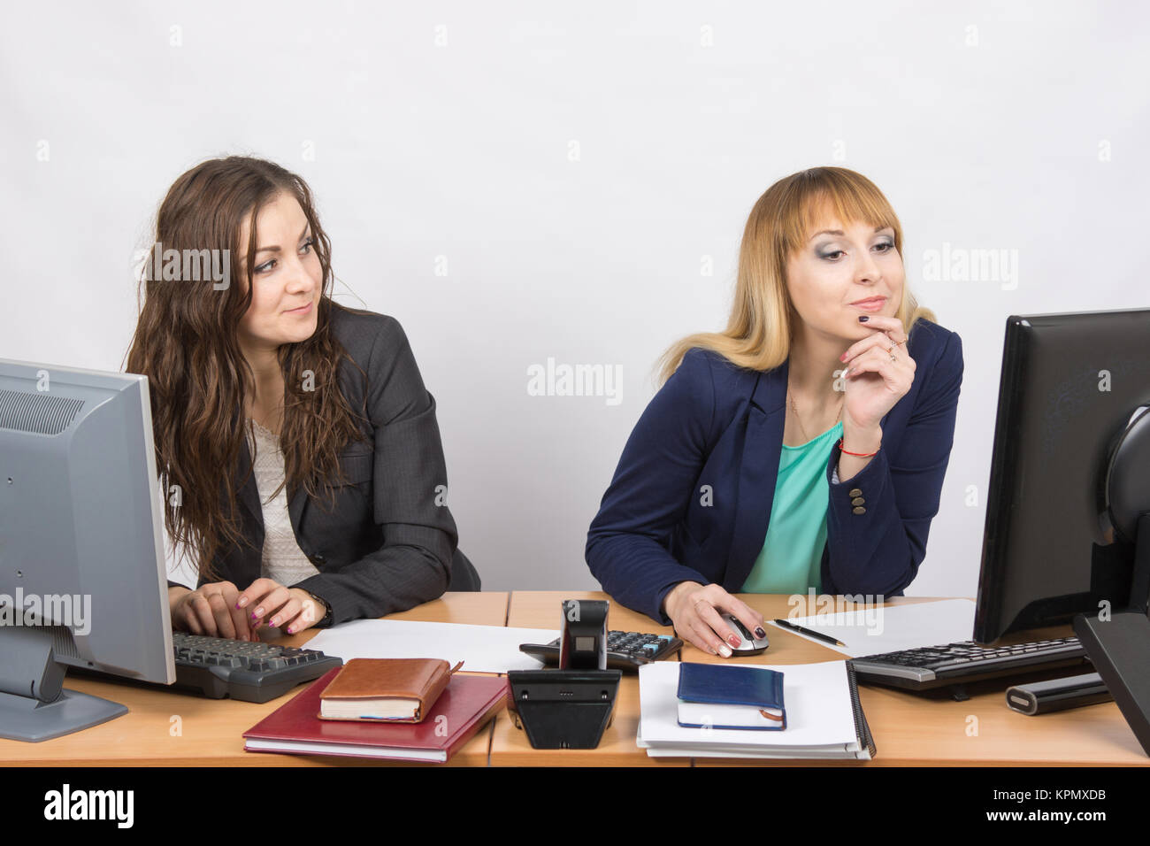 Office worker looking with distaste at the colleague sitting next to ...