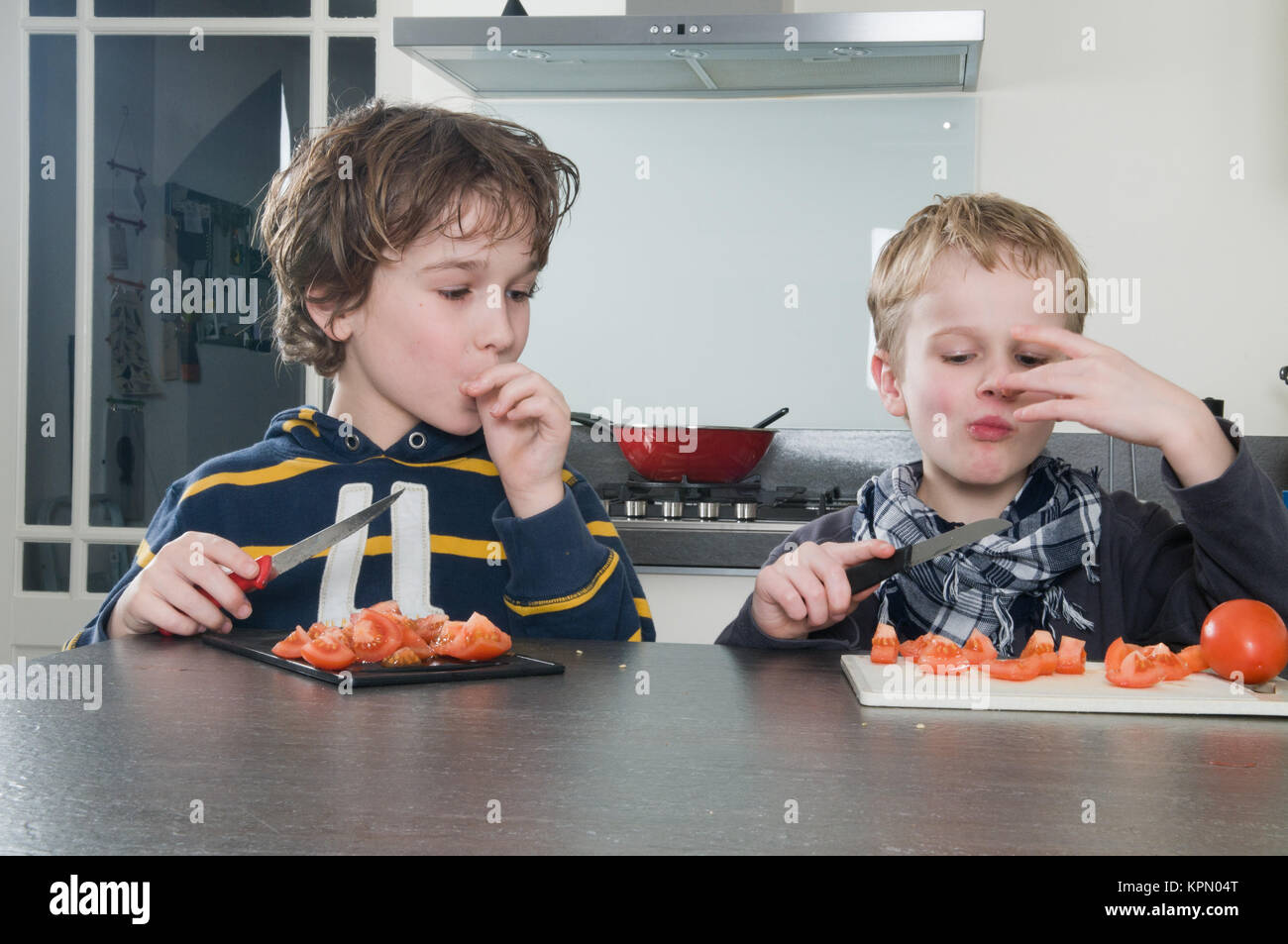 Boys tasting tomato Stock Photo - Alamy