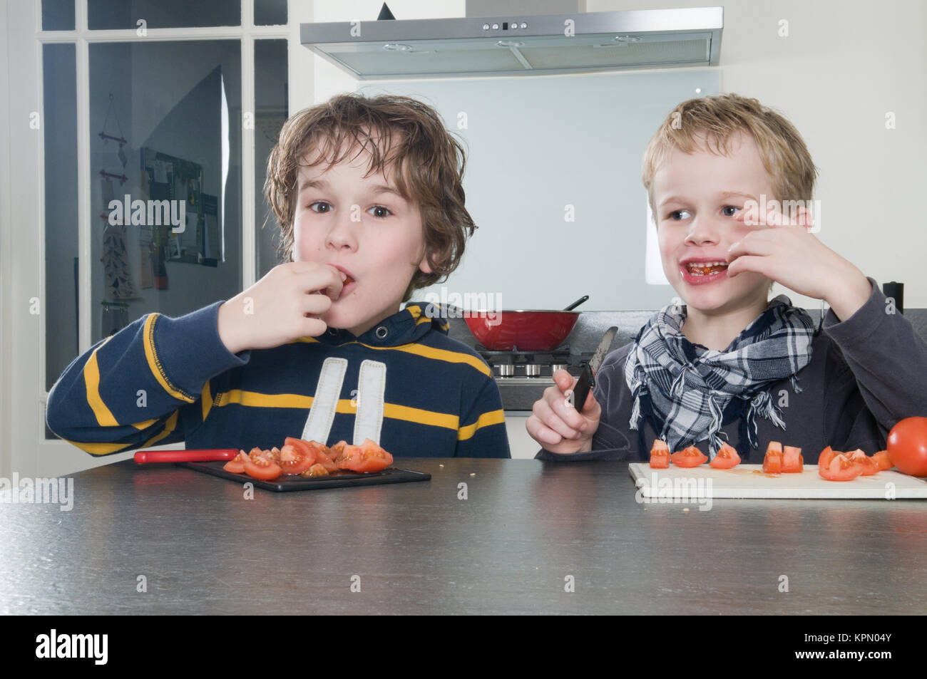 Boys tasting tomato Stock Photo - Alamy