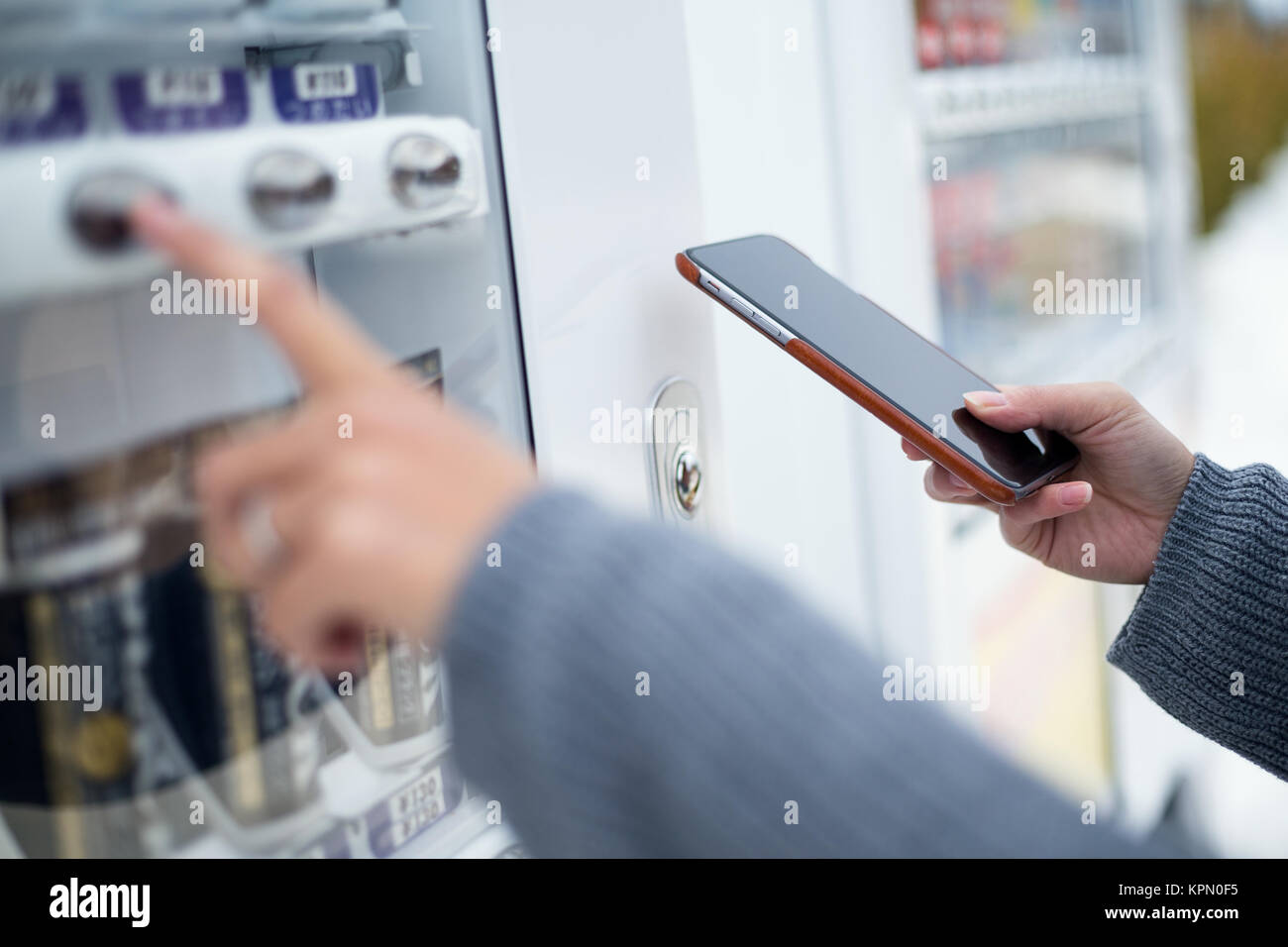 Woman using cellphone to pay the vending machine Stock Photo - Alamy