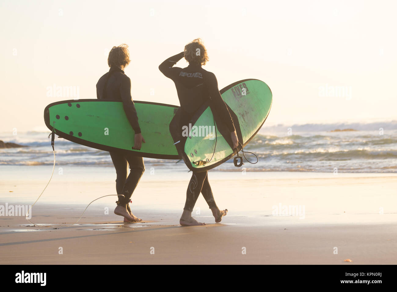 Surfers on beach with surfboard Stock Photo - Alamy