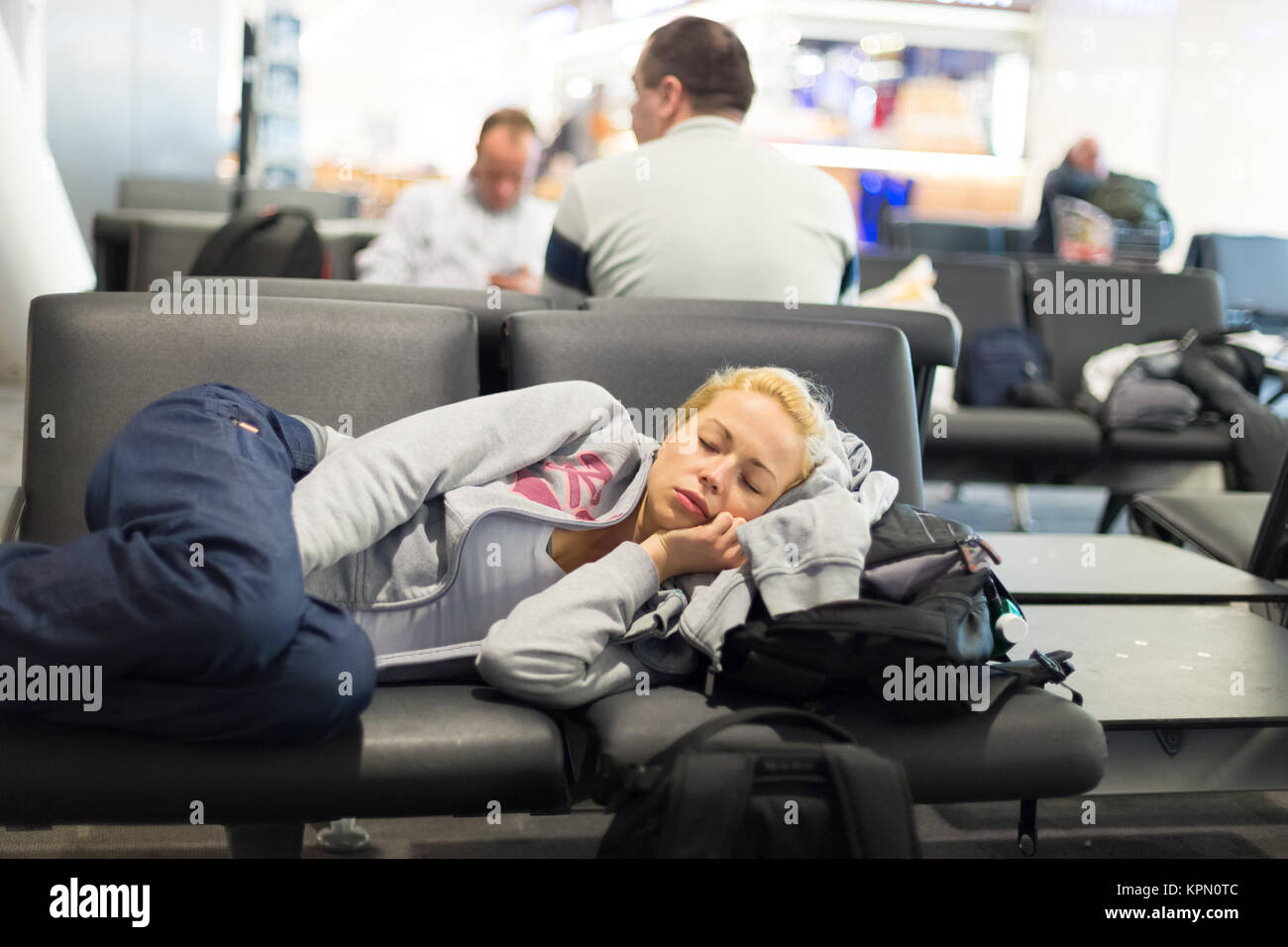 Tired female traveler sleeping on airport Stock Photo - Alamy