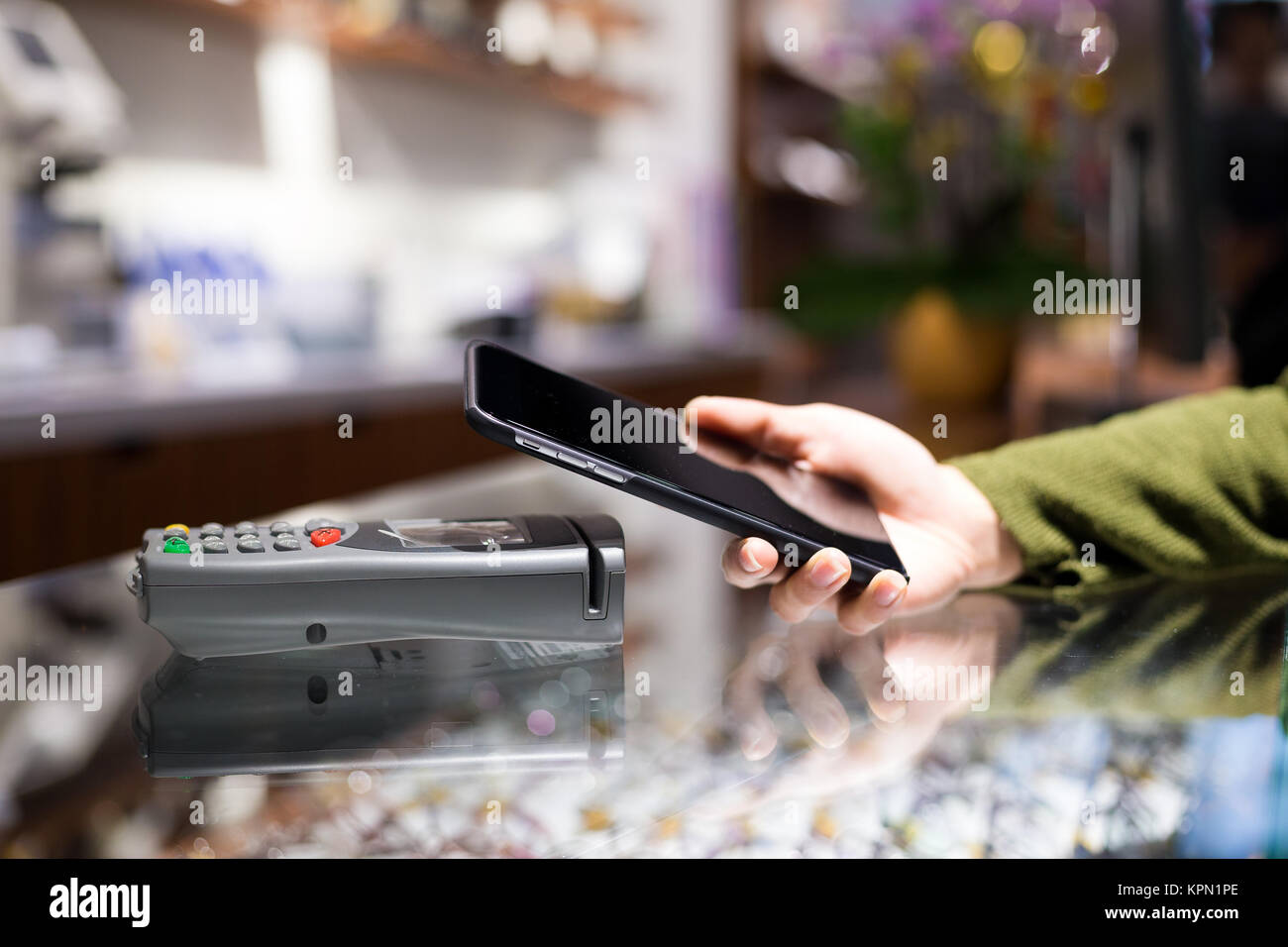 Woman paying on mobile phone by NFC Stock Photo - Alamy
