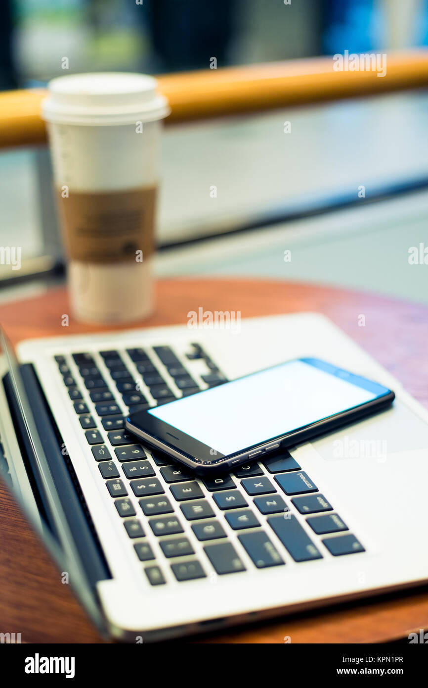 Cellphone and laptop computer in cafe shop Stock Photo - Alamy