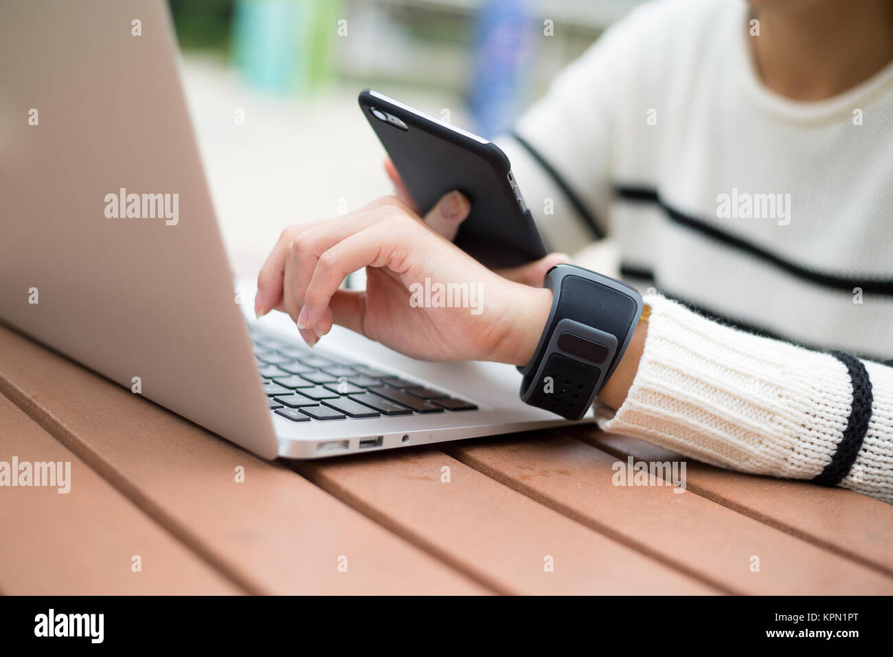 Woman use of laptop computer and cellphone Stock Photo - Alamy