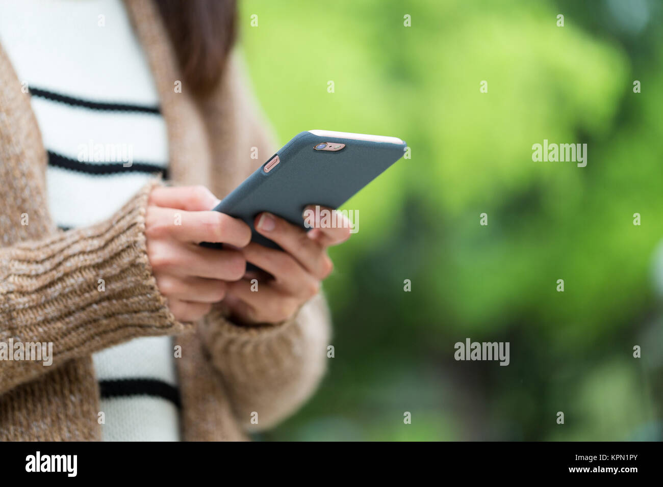 Woman use of mobile phone over green background Stock Photo - Alamy