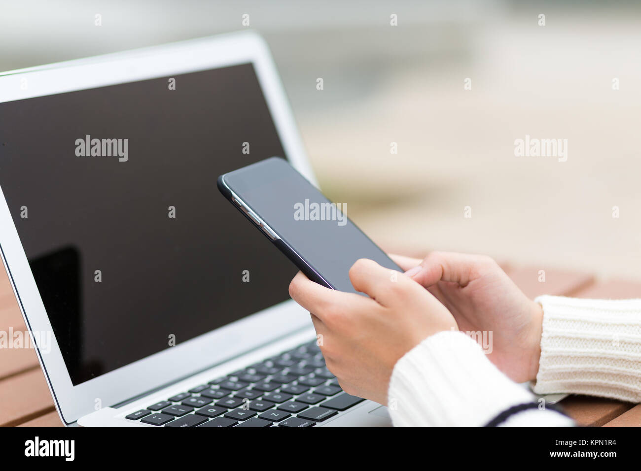 Woman use of cellphone and laptop computer Stock Photo - Alamy