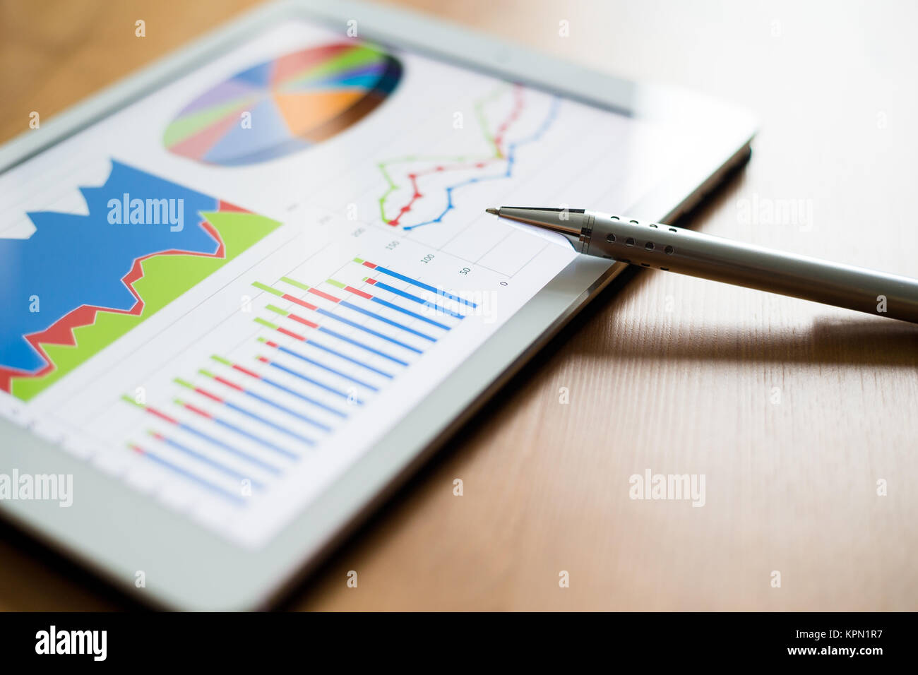 Workplace with digital tablet showing charts and diagram Stock Photo ...