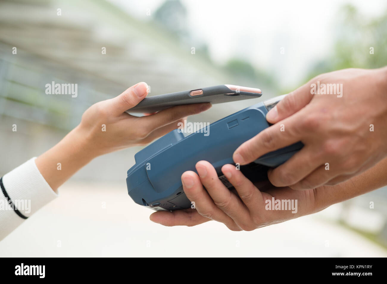 Woman pay on the pos machine with cellphone Stock Photo - Alamy