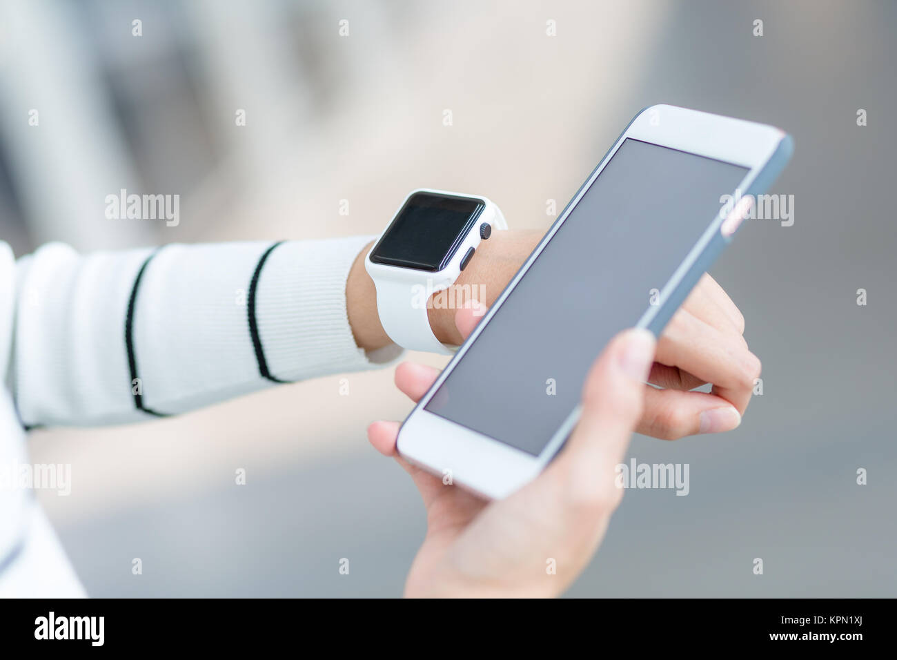 Woman wearing smartwatch and connecting to cellphone Stock Photo - Alamy